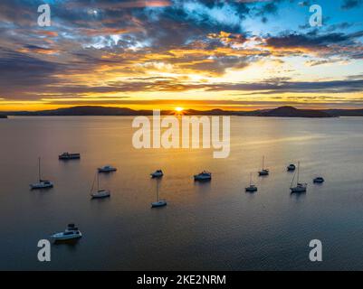 Sun rising over Brisbane Water with clouds and boats at Koolewong and ...