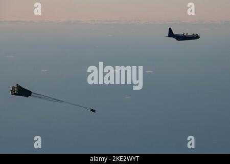 A palletized munitions system falls from the cargo hold of a 352d ...