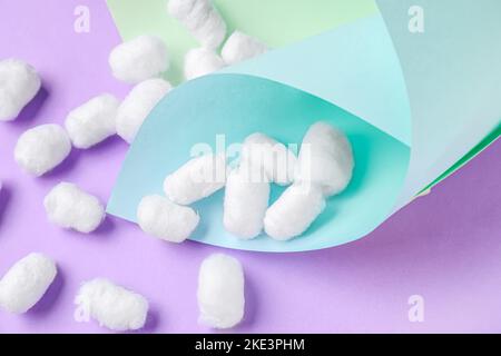 Paper sheets with cotton balls on lilac background Stock Photo - Alamy