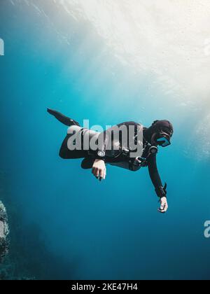 A vertical shot from depths of the Red Sea and a scuba diver exploring ...