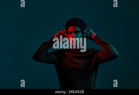 man in headphones over neon lights of night club Stock Photo - Alamy