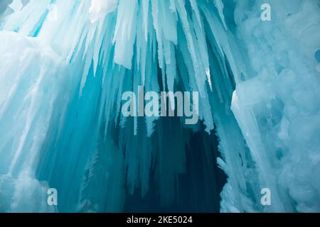 A low angle of an ice formation with hanging huge blue icicles Stock ...