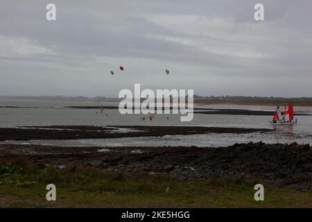 Coastal scene with boats and kite surfing, very windy, bad weather. The ...