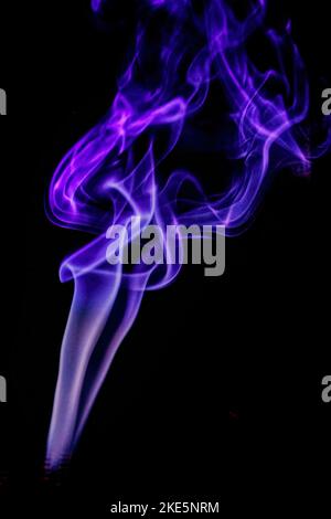 A beautiful shot of a colorful cone incense smoke trails isolated on ...