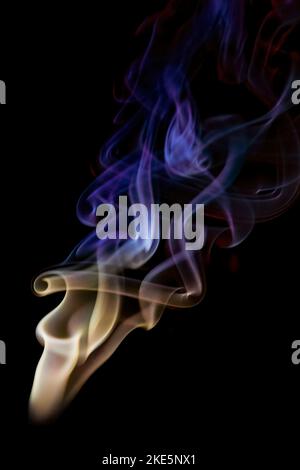 A beautiful shot of a colorful cone incense smoke trails isolated on ...