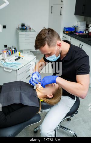 The orthodontist puts metal braces on the patient's teeth. Orthodontic ...