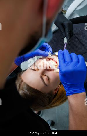 The orthodontist puts metal braces on the patient's teeth. Orthodontic ...