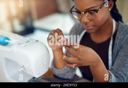 female dressmaker putting thread into needle Stock Photo - Alamy