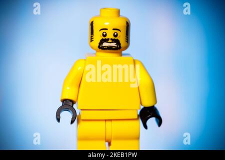 yellow lego figure with an angry face on a blue background. High ...