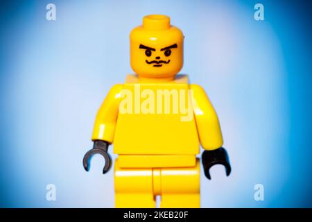 yellow lego figure with an angry face on a blue background. High ...