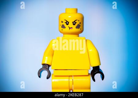 yellow lego figure with an evil face on a blue background with a ...