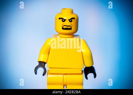 yellow lego figure with an evil face on a blue background with a ...