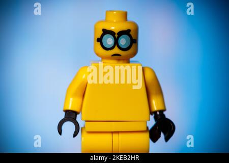 yellow lego figure with an evil face on a blue background with a ...