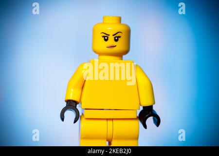 yellow lego figure with a sarcastic face on a blue background. High ...