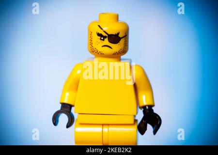yellow lego figure with an angry face on a blue background. High ...