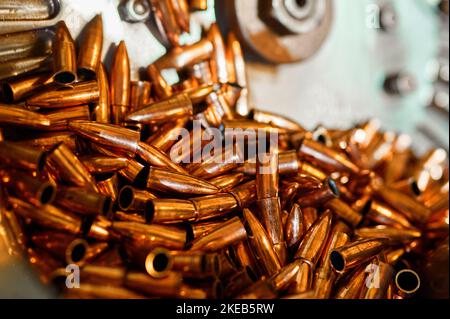 Pile of orange bullets and turning wheel at production line Stock Photo ...