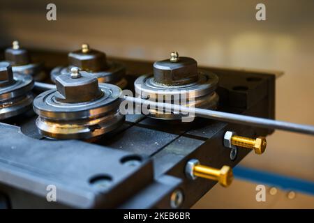 Metal cable pulled out through rollers line on machine tool Stock Photo ...