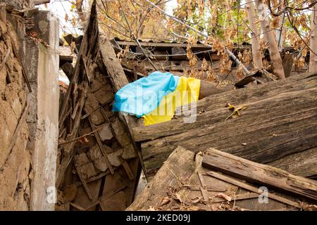 A residential building was blown up and the flag of Ukraine lies on the ...