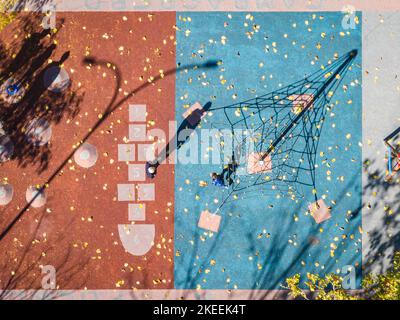 Aerial view of a colorful playground at dusk, with the shadows of the ...