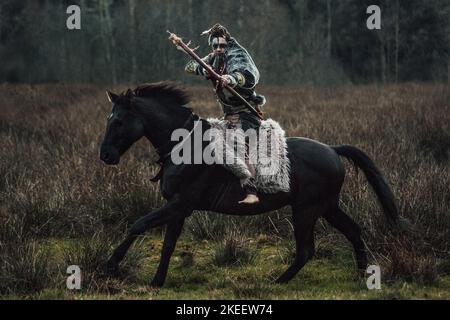 Black man on horseback (Equus caballus) riding horse in the water of ...