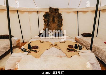 The interior of a rustic-style tent with hunting equipment and ...