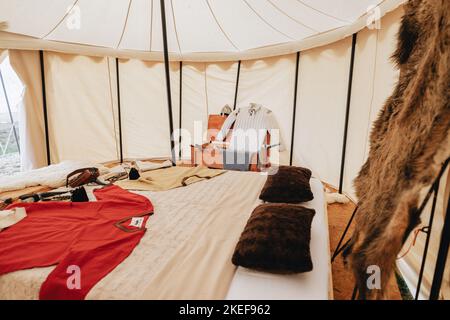 The interior of a rustic-style tent with hunting equipment and ...