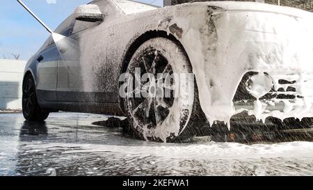 Washing luxury car on a touchless car wash. Washing sedan car with foam ...