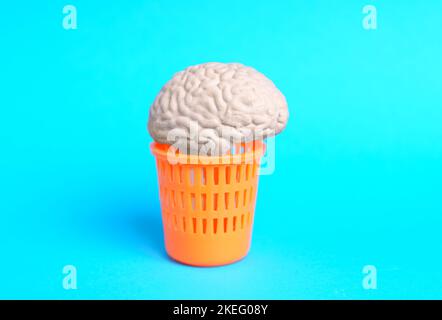 Human brain in trash can and toy home cleaning tools arranged on blue ...
