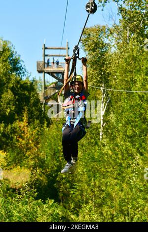 Children high adventure on zipline course through forest canopy with ...