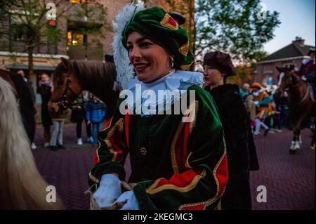 A female St Nicholas' helper is seen carrying sweets to give to the ...