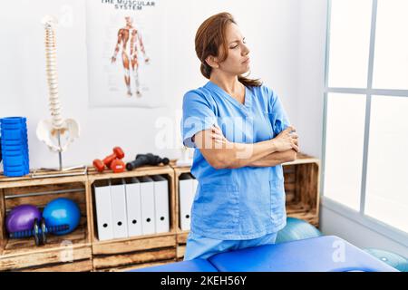 Middle age hispanic physiotherapist woman working at pain recovery ...