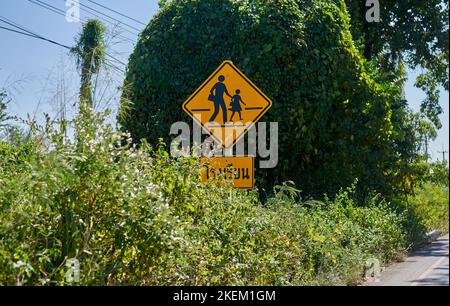 An overgrown roadside signpost showing children's crossing Stock Photo ...