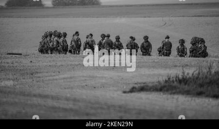 a circle of British army soldiers listening to their CO before setting ...