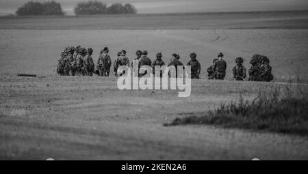a circle of British army soldiers listening to their CO before setting ...