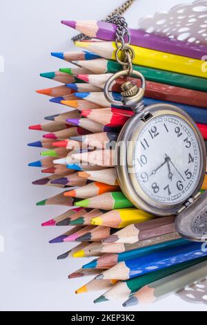 Retro style pocket watch and color pencils Stock Photo - Alamy
