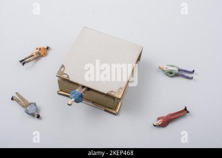 Tiny figurine of men models found beside a book Stock Photo - Alamy