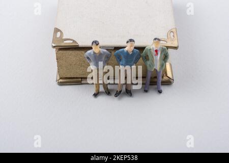 Tiny figurine of men models found beside a book Stock Photo - Alamy