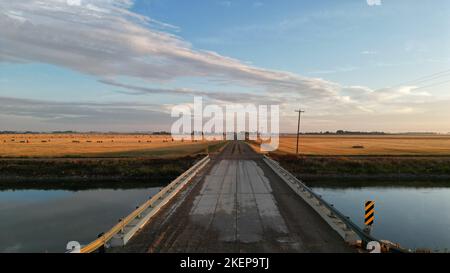 Drone view during sunrise over a farm hay field and river in Alberta ...
