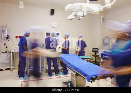 Operating room with working staff next to the patient Stock Photo - Alamy