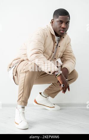 Tall handsome confident young man in a jacket sitting on the chair and ...