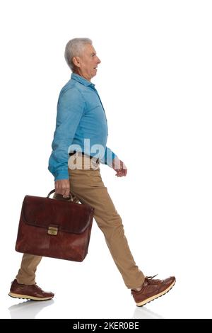 proud old man with bag holding fist up and cheering the winning in ...