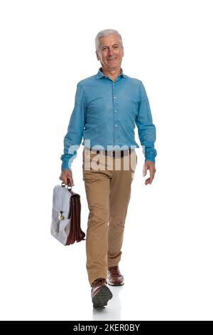 proud old man with bag holding fist up and cheering the winning in ...