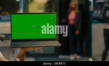 Laptop showing greenscreen display outdoors, food delivery service at ...