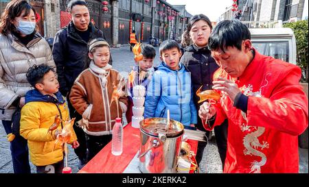 Folk artist Ma Diankun is performing the Sugar Figure Blowing Art which is an intangible ...