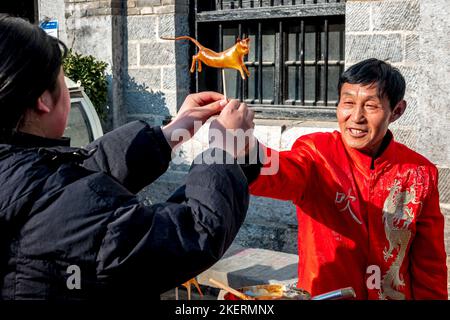 Folk artist Ma Diankun is performing the Sugar Figure Blowing Art which is an intangible ...