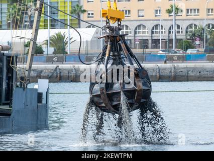 Dredger dredging oily silt from docks to increase depth for larger ...