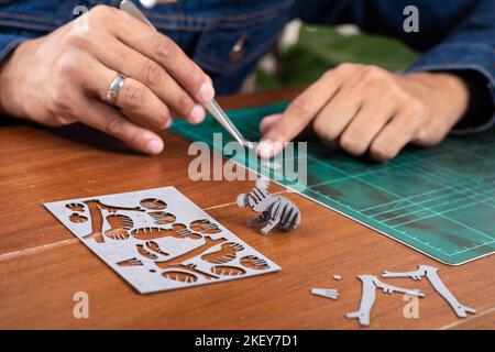 Assembling small cardboard model, the small cardboard parts are made ...