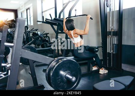 sporty woman performing an exercise to strengthen her back muscles ...