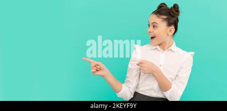 Young schoolchild pointing up portrait. Preteen schoolgirl looking at ...