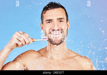 Water splash, portrait or man brushing teeth in studio with toothbrush ...
